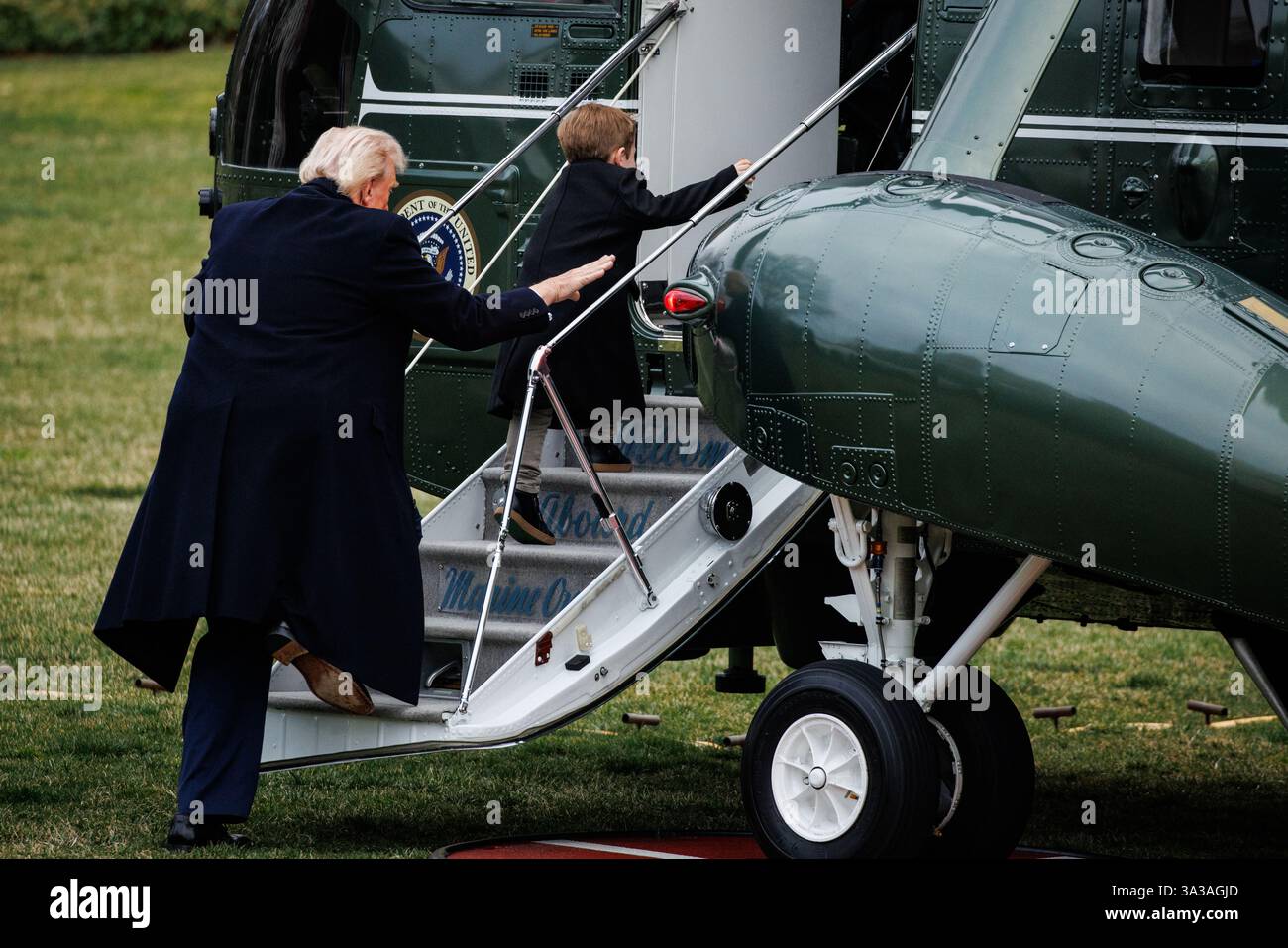 President Donald Trump’s foot catches on the stairs after lifting up X ...