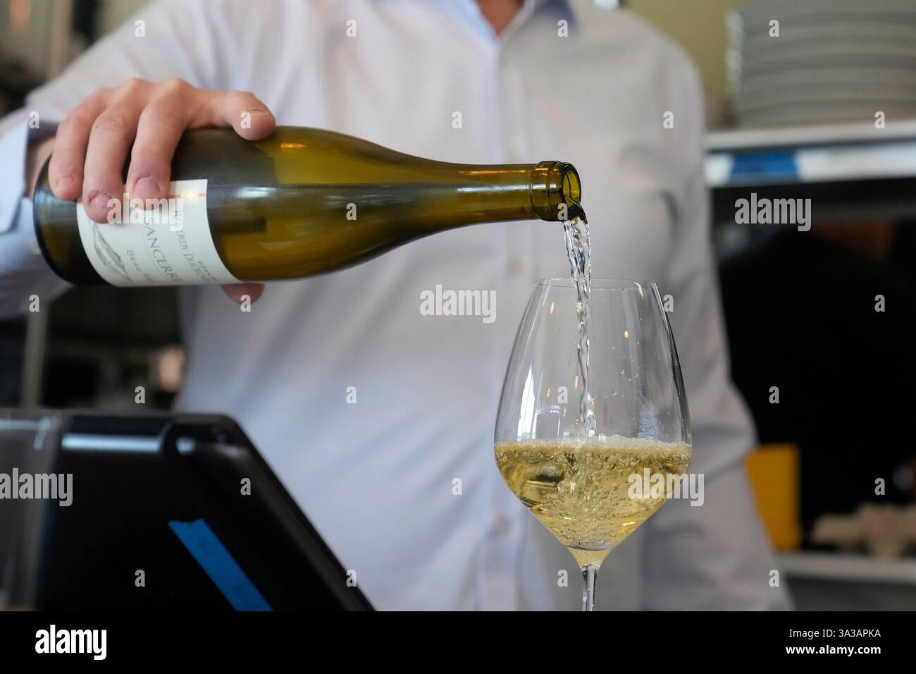 Alex Prodhomme, general manager at Galinette, a French bistro, pours a ...