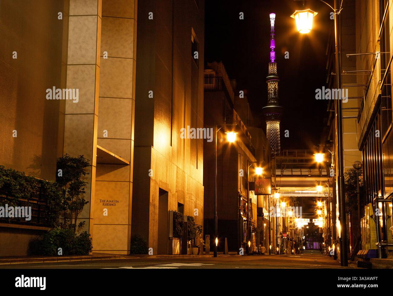 View of Tokyo Skytree at night looking down a small street in Asakusa ...