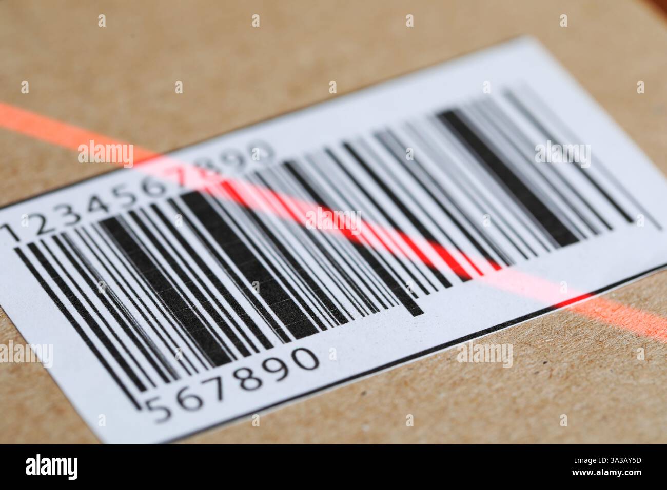 Parcel with label, closeup. Red laser light on barcode for scanning ...