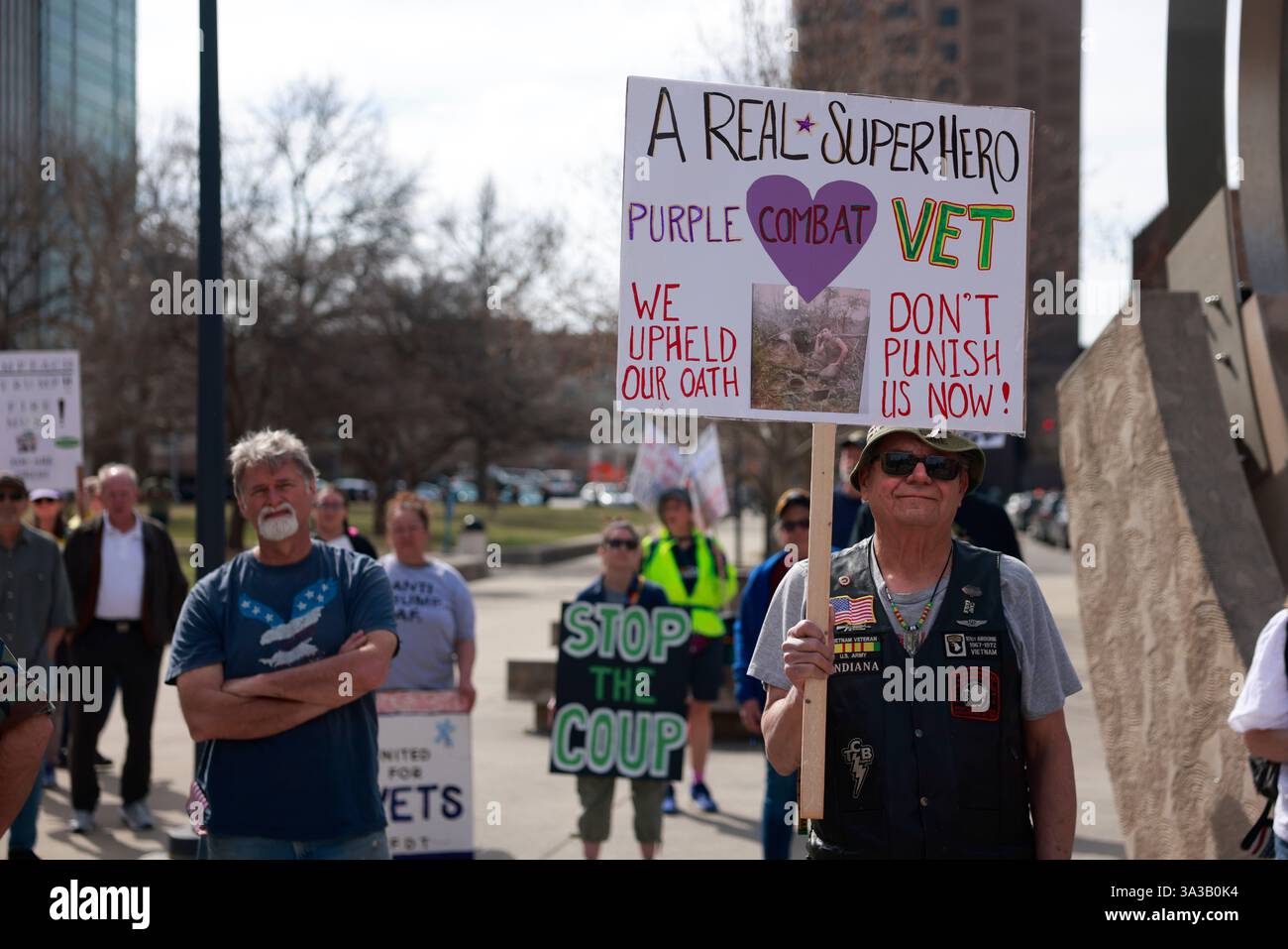 INDIANAPOLIS, INDIANA - MARCH 14: A protester holds a sign reading, “We ...