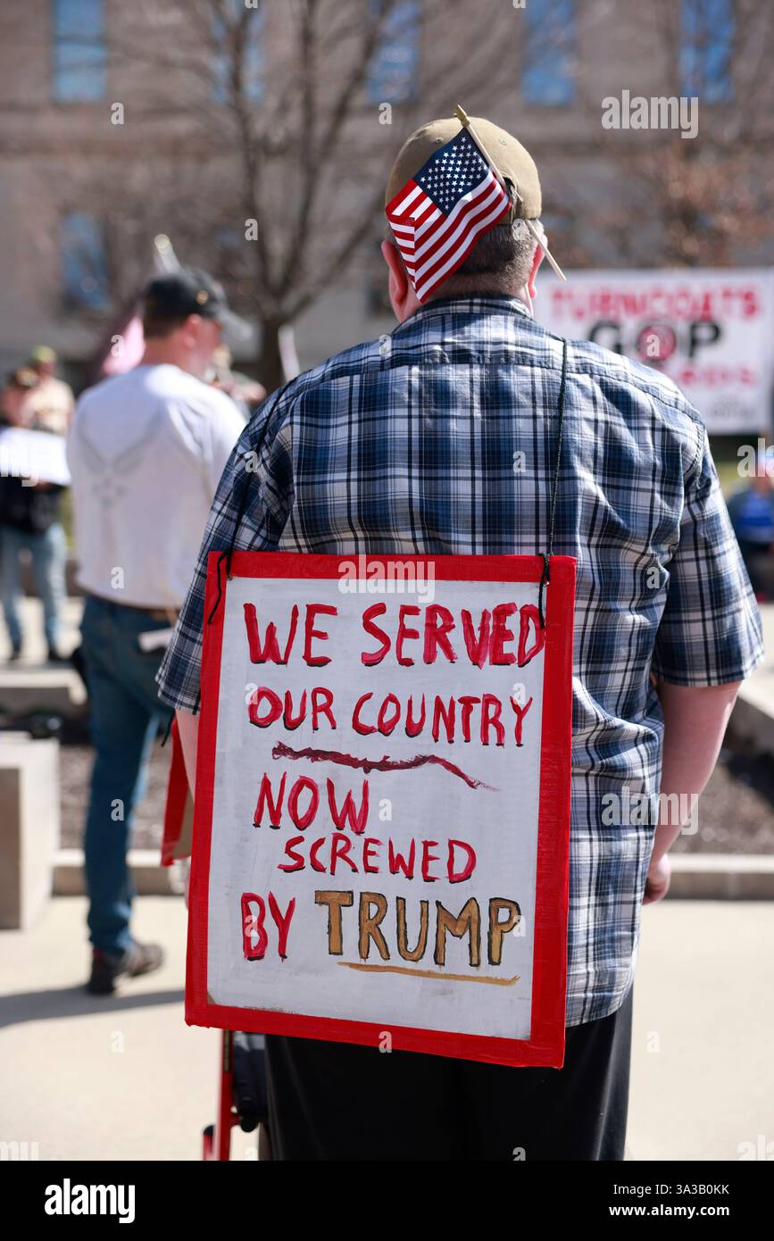 INDIANAPOLIS, INDIANA - MARCH 14: A protester wears a sign reading, “We ...
