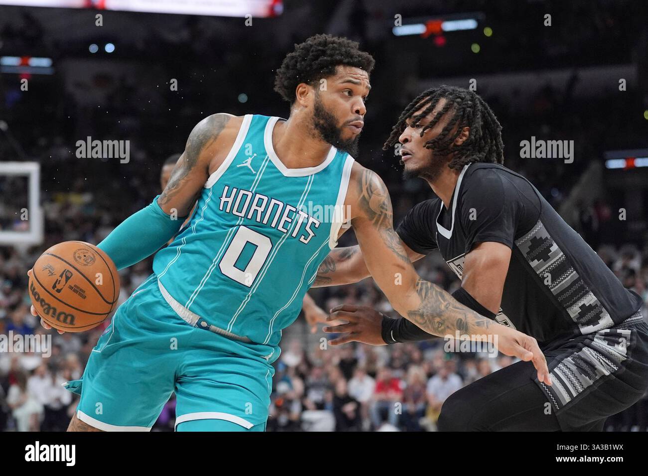 Charlotte Hornets forward Miles Bridges (0) drives around San Antonio Spurs guard Stephon Castle ...