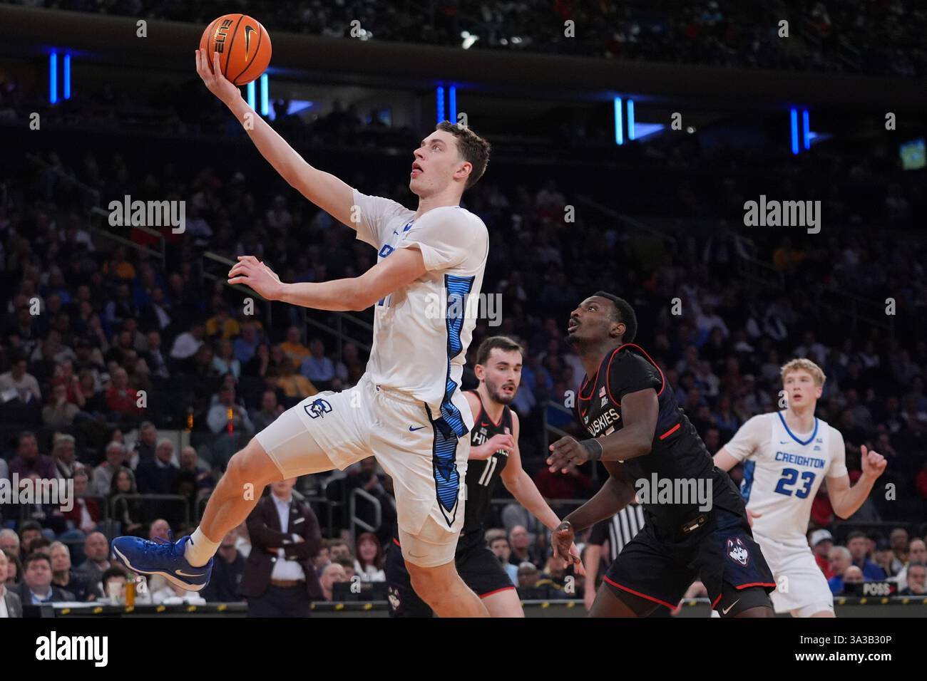 Creighton's Ryan Kalkbrenner, left, drives past UConn's Samson Johnson ...