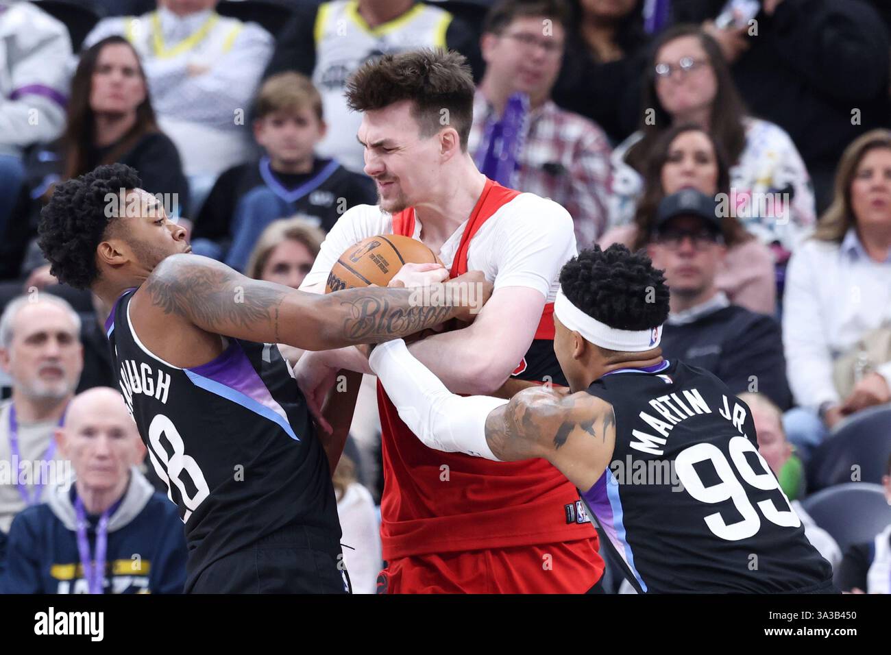 Toronto Raptors center Colin Castleton, middle, is tied up by Utah Jazz ...