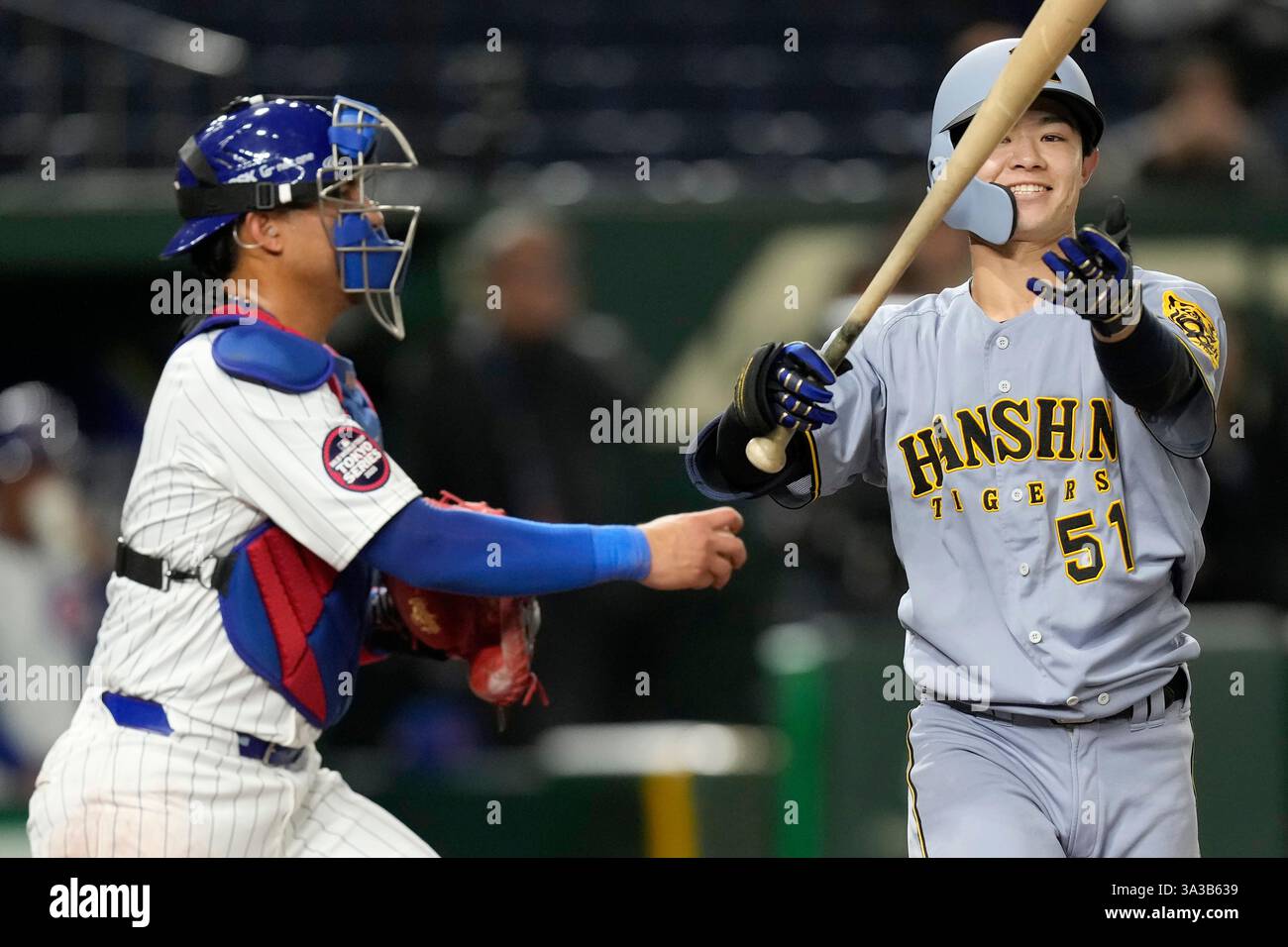 Hanshin Tigers' Takumu Nakano (51) reacts after striking out next to Chicago Cubs catcher Miguel ...