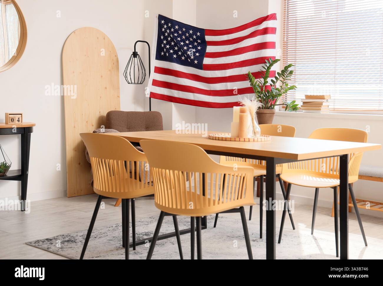Light dining room with chairs, table and USA flag on wall Stock Photo ...