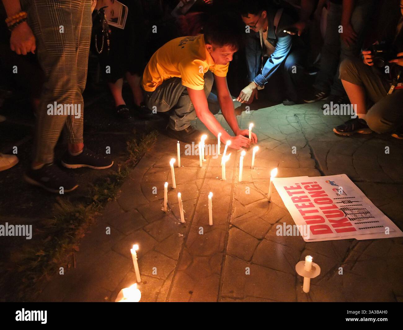 A protester lights a candle in memory of his slain relative in the Ex ...