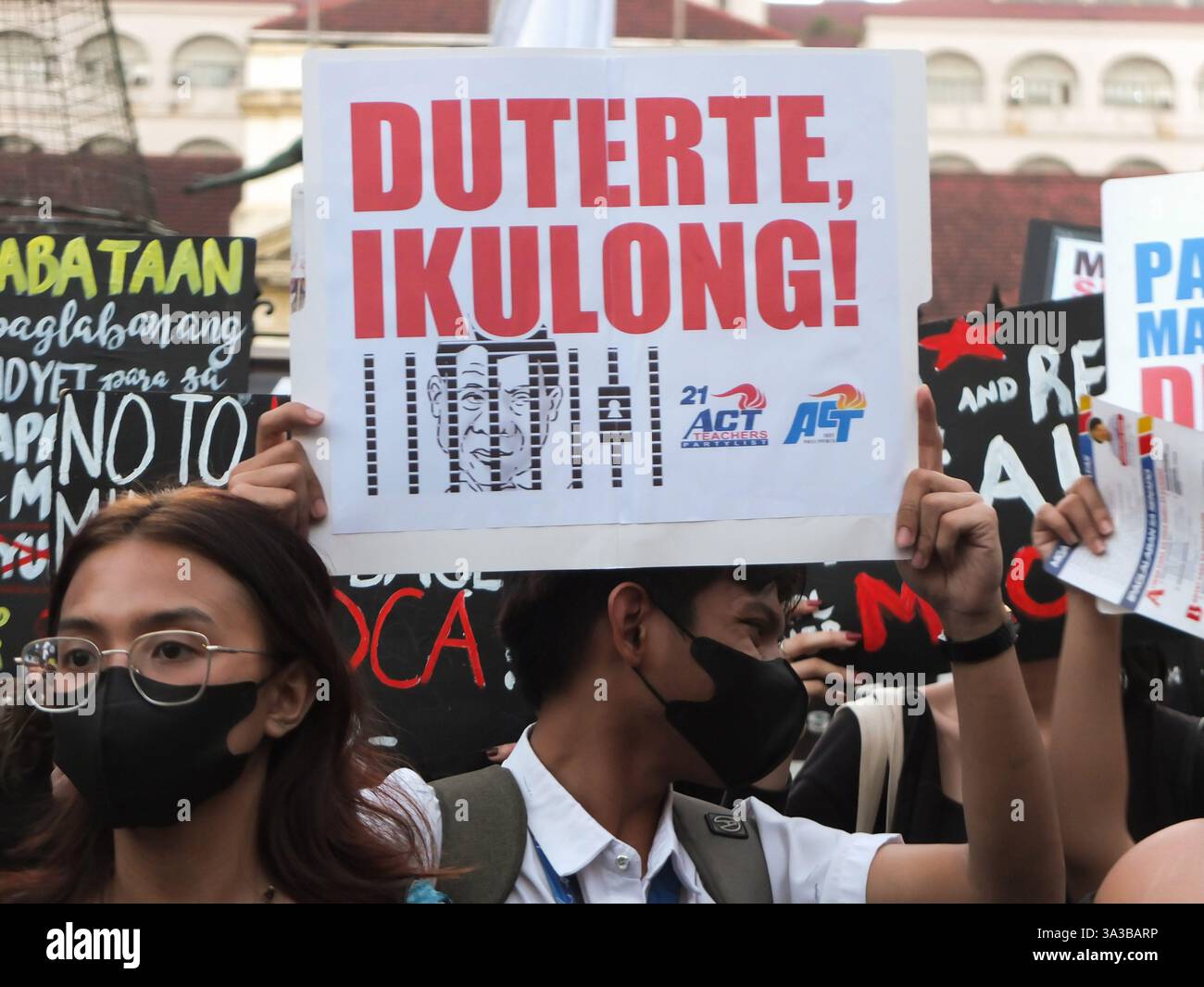 A protester holds a placard with a slogan that former Philippine ...