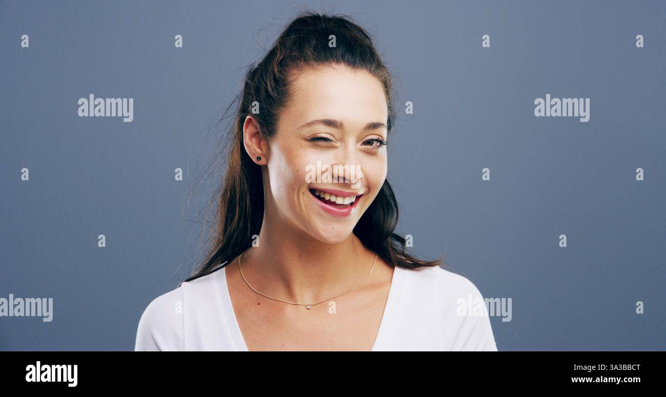 Wink, smile and portrait of woman in studio for secret, agreement and ...