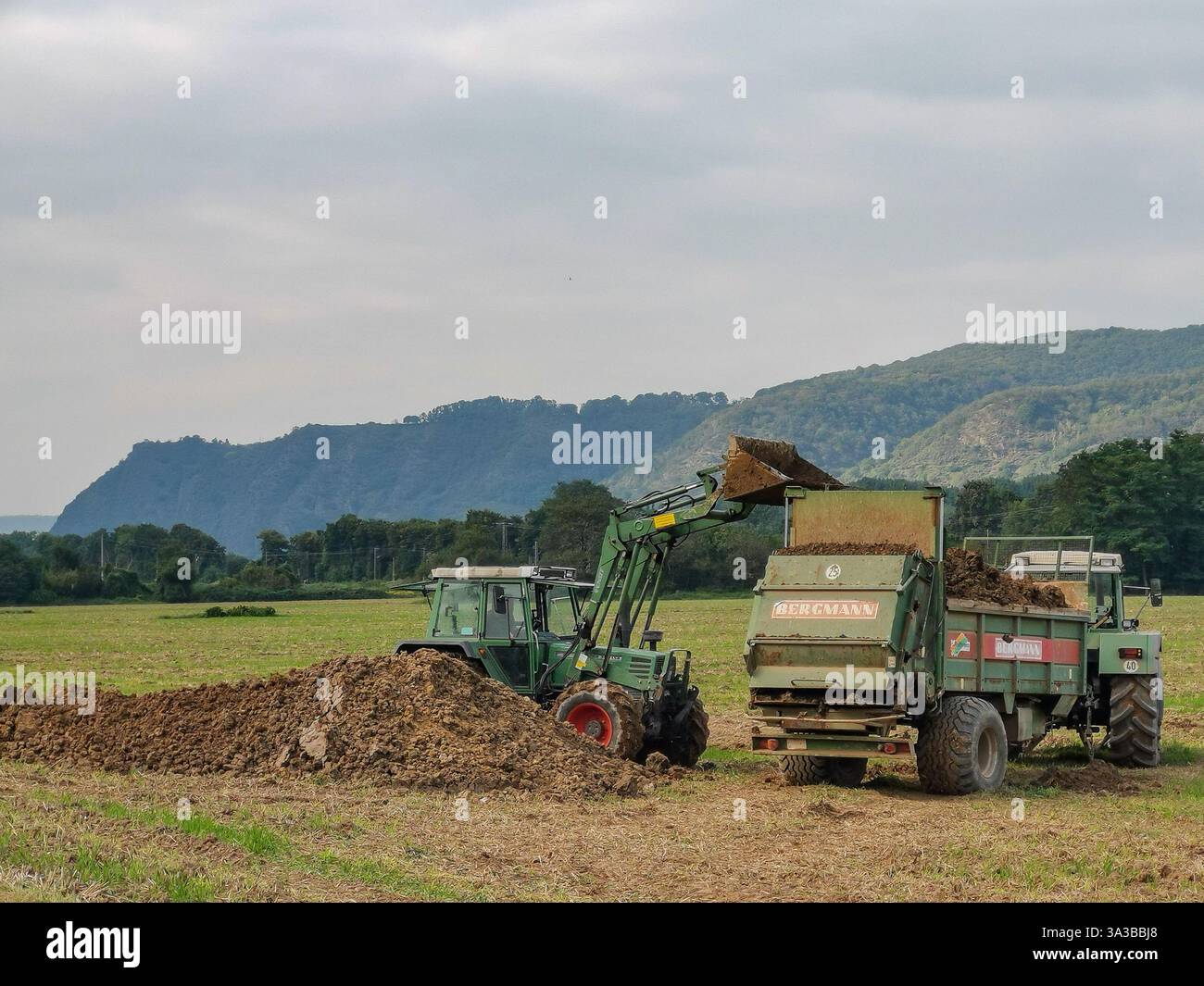 A tractor loads soil cutting onto a tumbril Stock Photo - Alamy