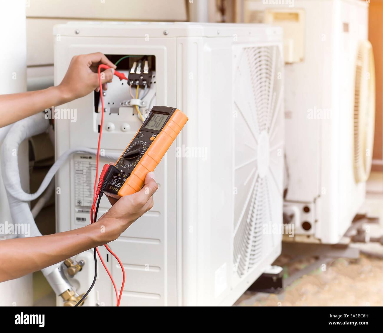 Air conditioner repairman using electricity meter to check air ...