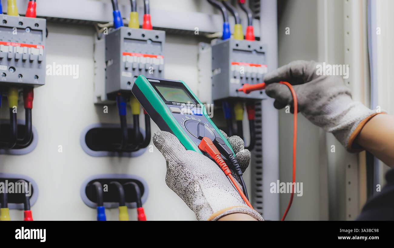Electrical engineer tests the operation of the electric control cabinet ...
