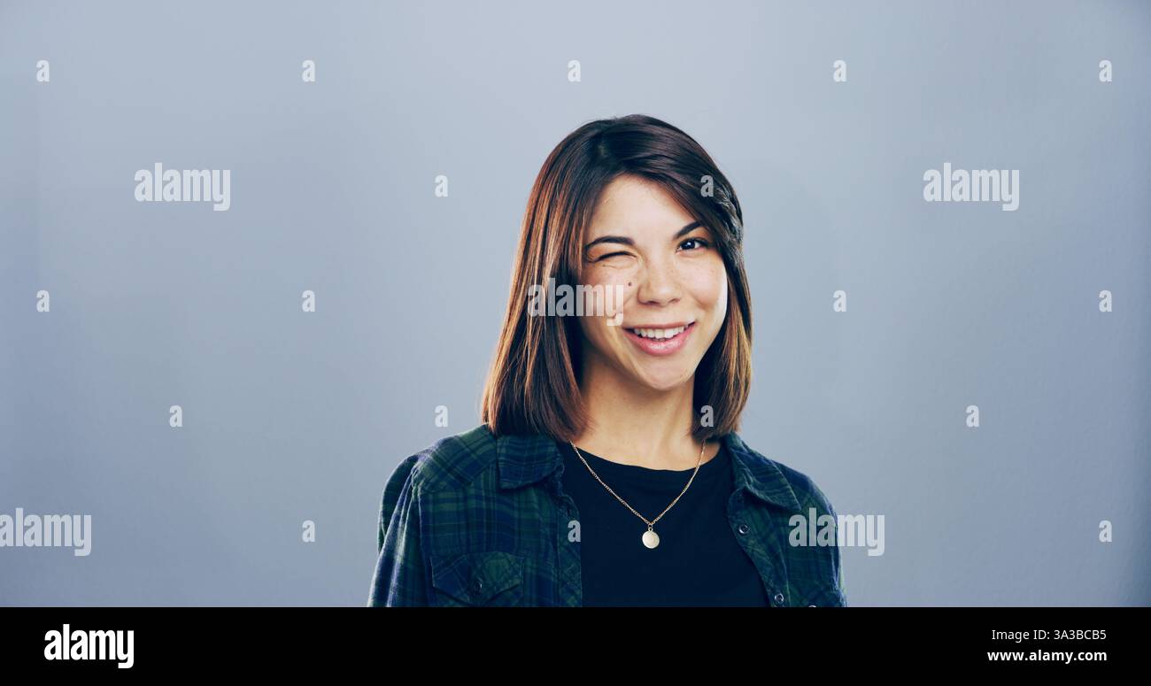 Studio, woman and portrait with wink for silly, emoji expression and ...