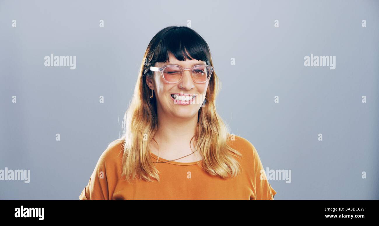 Woman, wink and sunglasses with smile in studio, emoji and flirt with ...