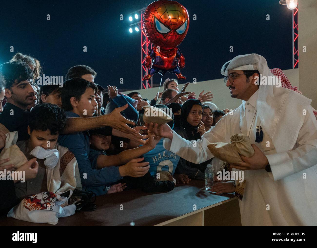 Doha Ramadan Garangao Festival 2025 A man is distributing bags of ...