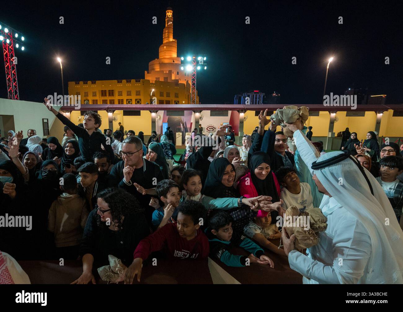 Doha Ramadan Garangao Festival 2025 A man is distributing bags of ...