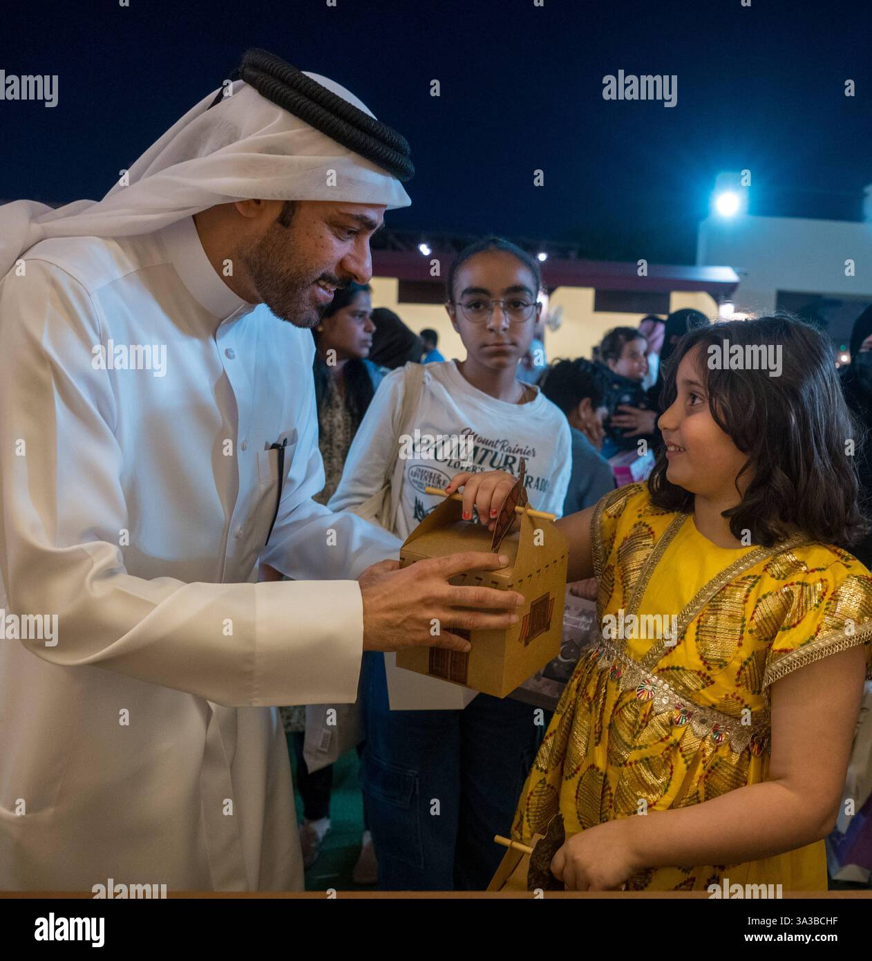 Doha Ramadan Garangao Festival 2025 A man is distributing bags of ...