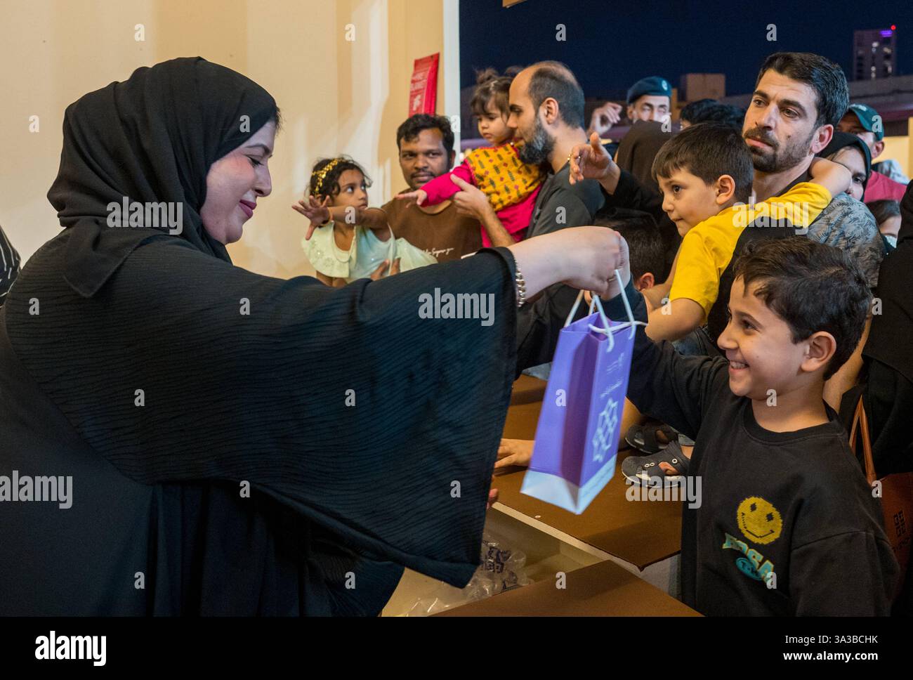 Doha Ramadan Garangao Festival 2025 A woman is distributing bags of ...