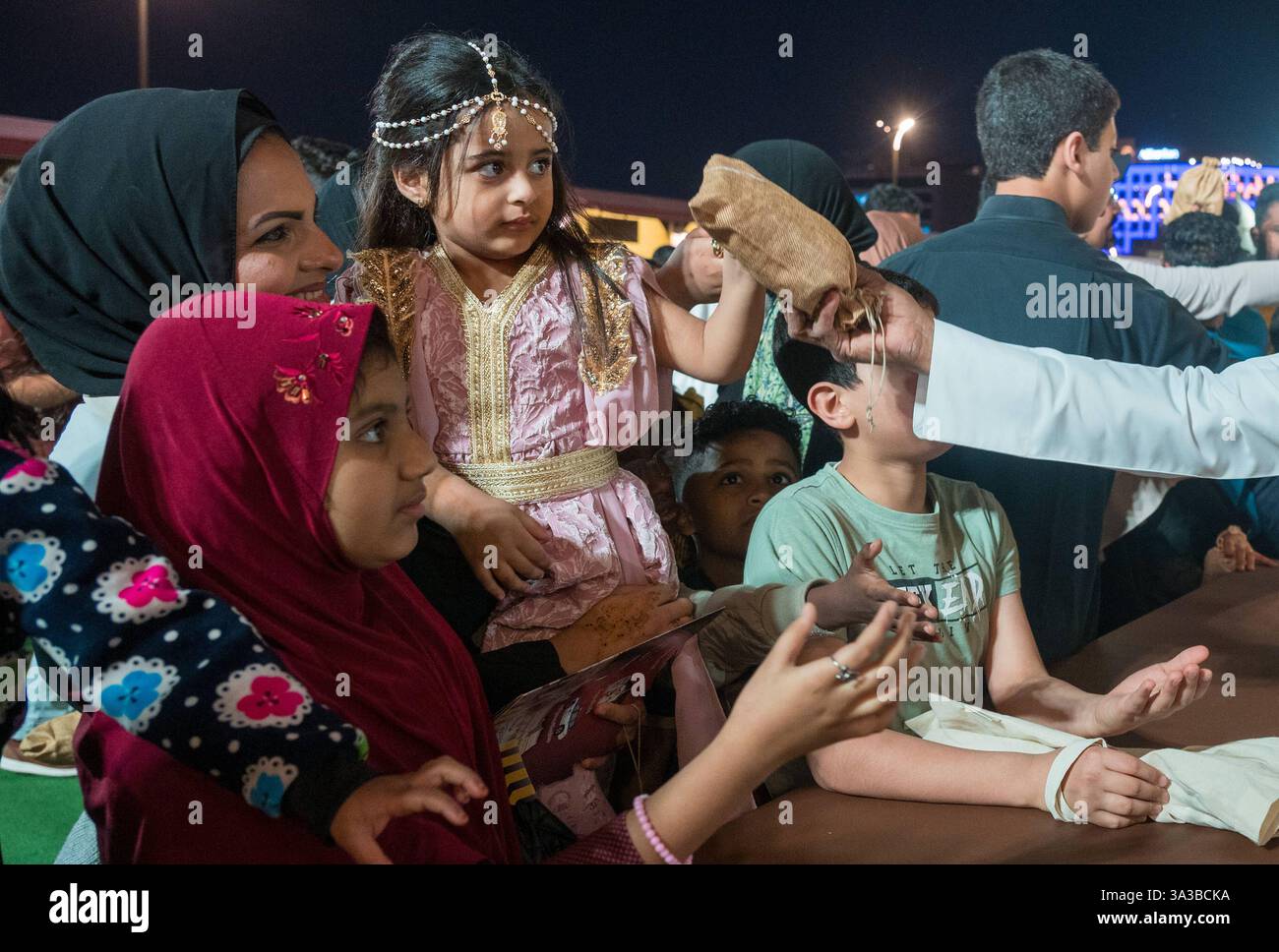 Doha Ramadan Garangao Festival 2025 A man is distributing bags of ...
