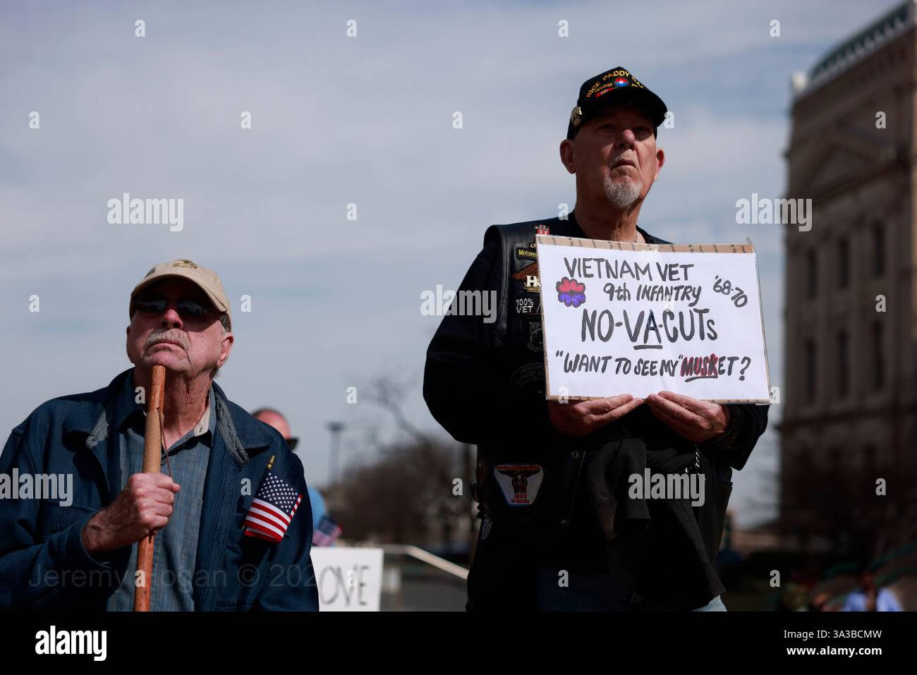 A Vietnam Veteran holds signs against VA cuts while United States ...