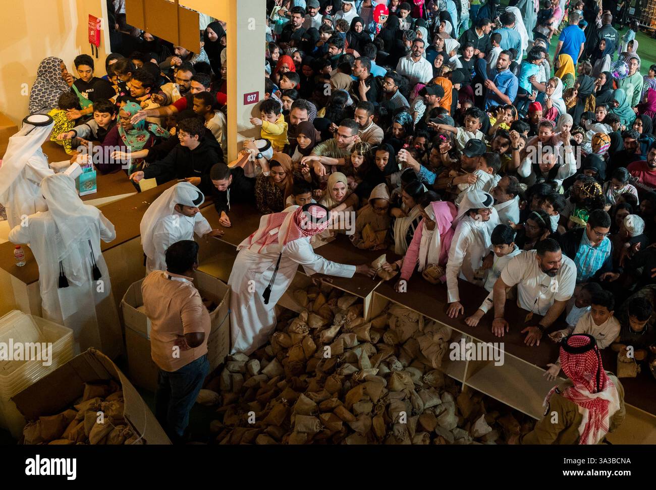 Doha Ramadan Garangao Festival 2025 Qatari men distributing bags of ...