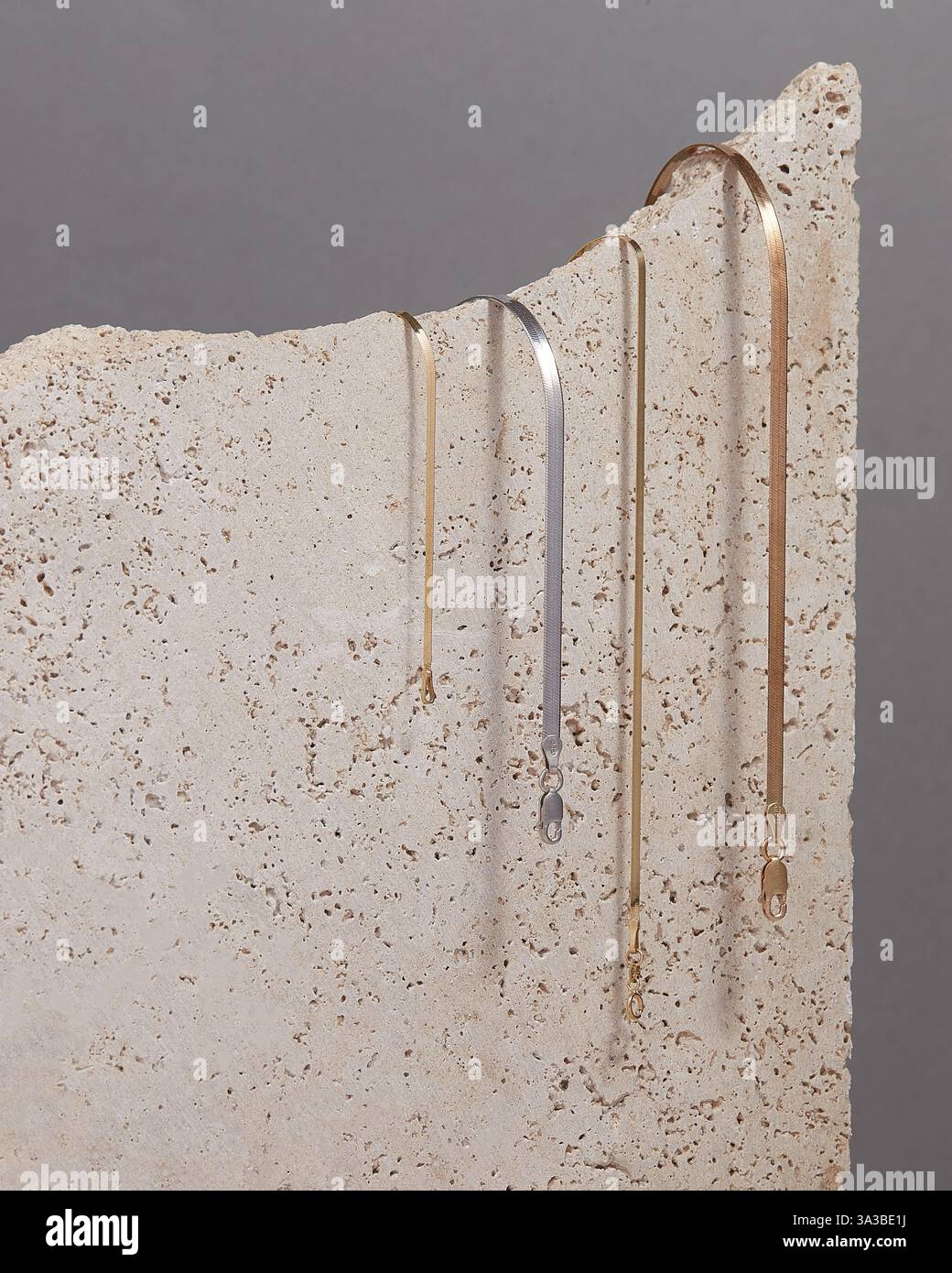 Side profile view of elegant gold and silver snake chains arranged on a ...