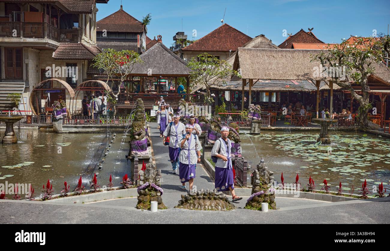 Tourists wearing sarongs visit Ubud Water Palace at Saraswati Temple ...