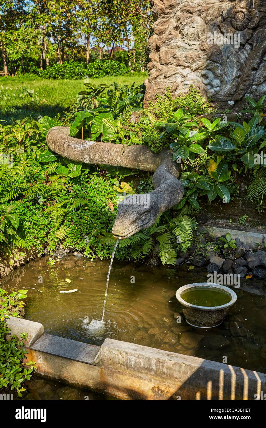 Intricately carved snake fountain statue in the garden at the Sacred ...