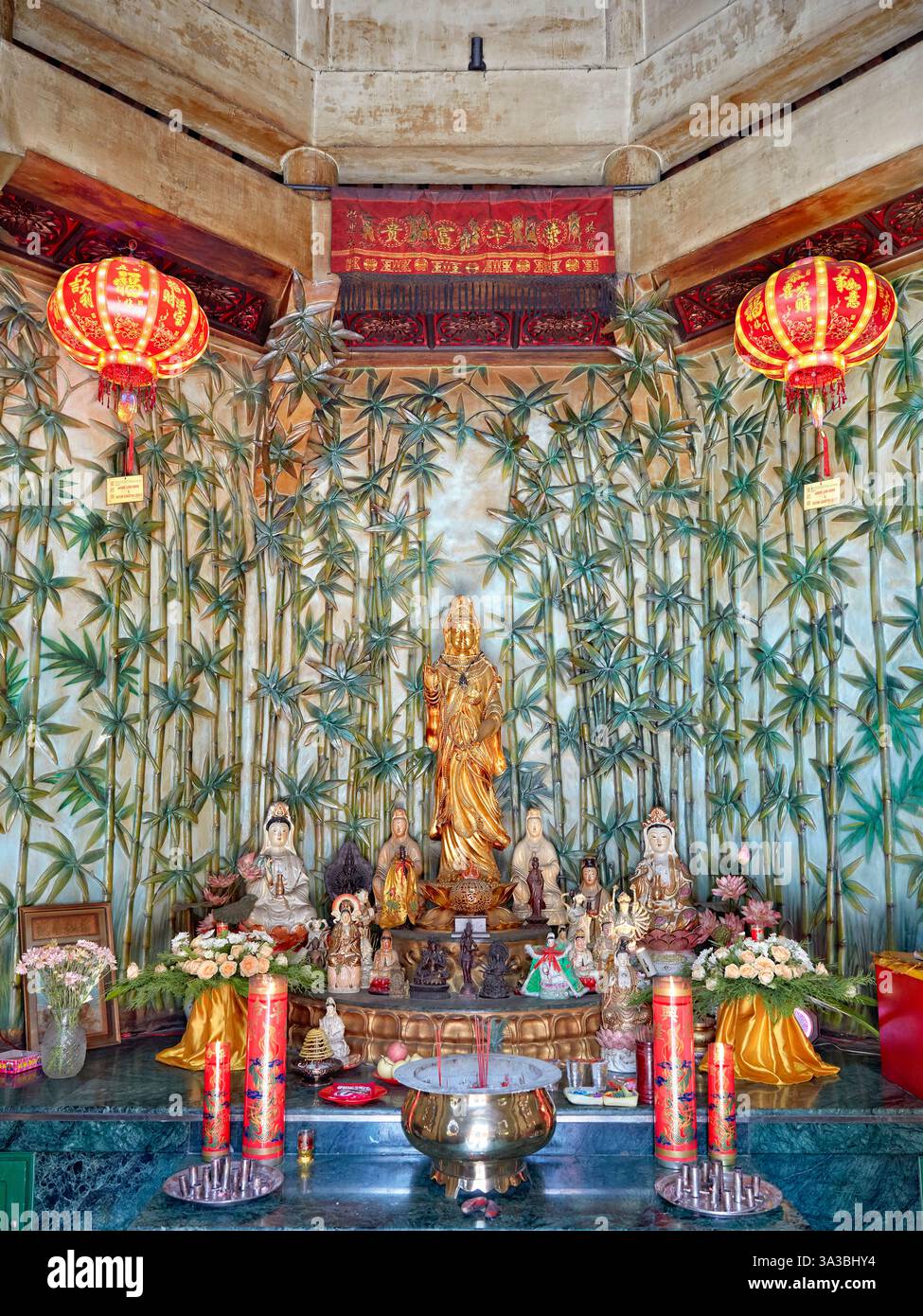 Golden statuette of Guanyin, goddess of mercy on a small altar at ...