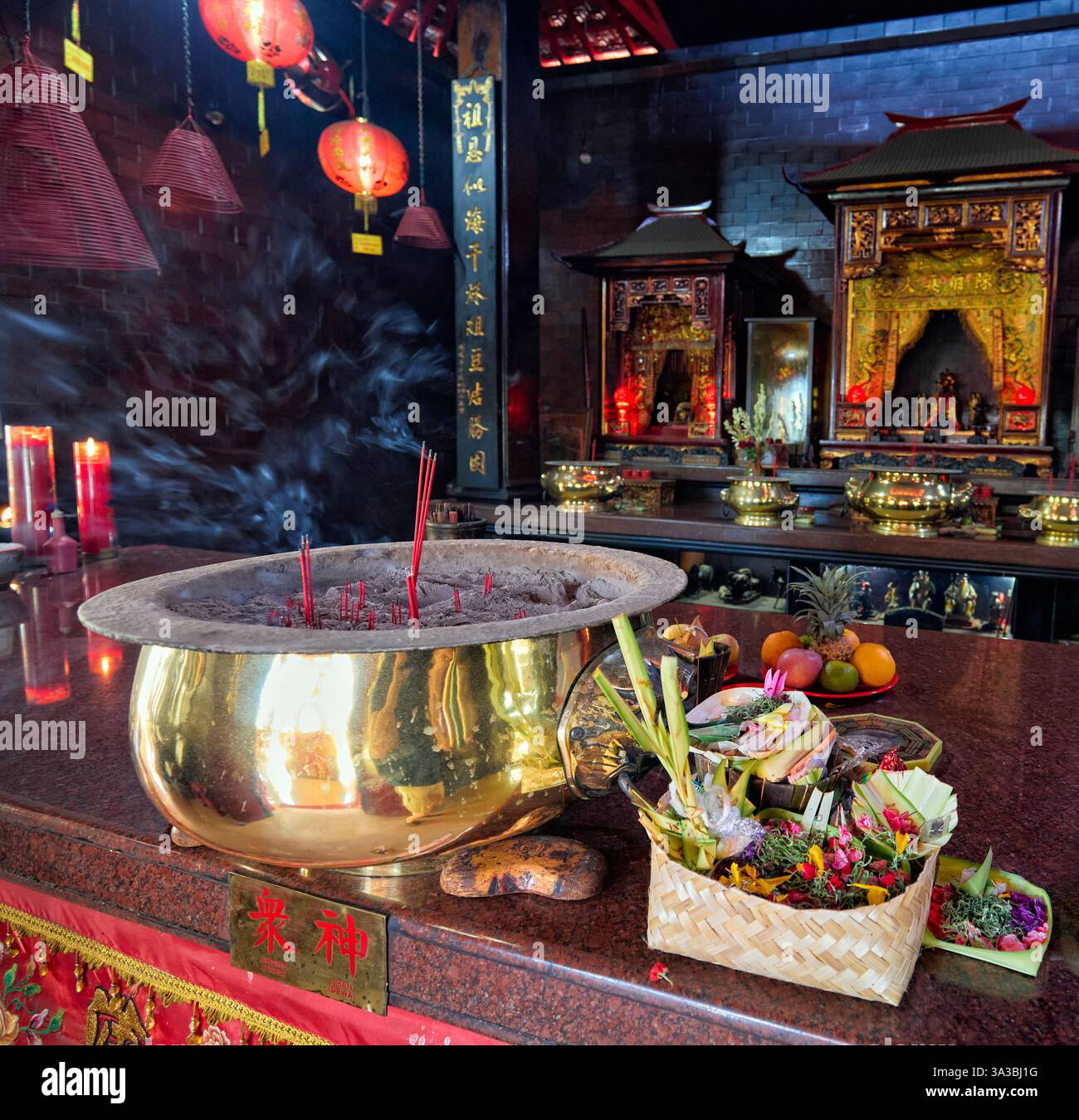 Golden urn with smoking incense sticks on the table at the altar in ...