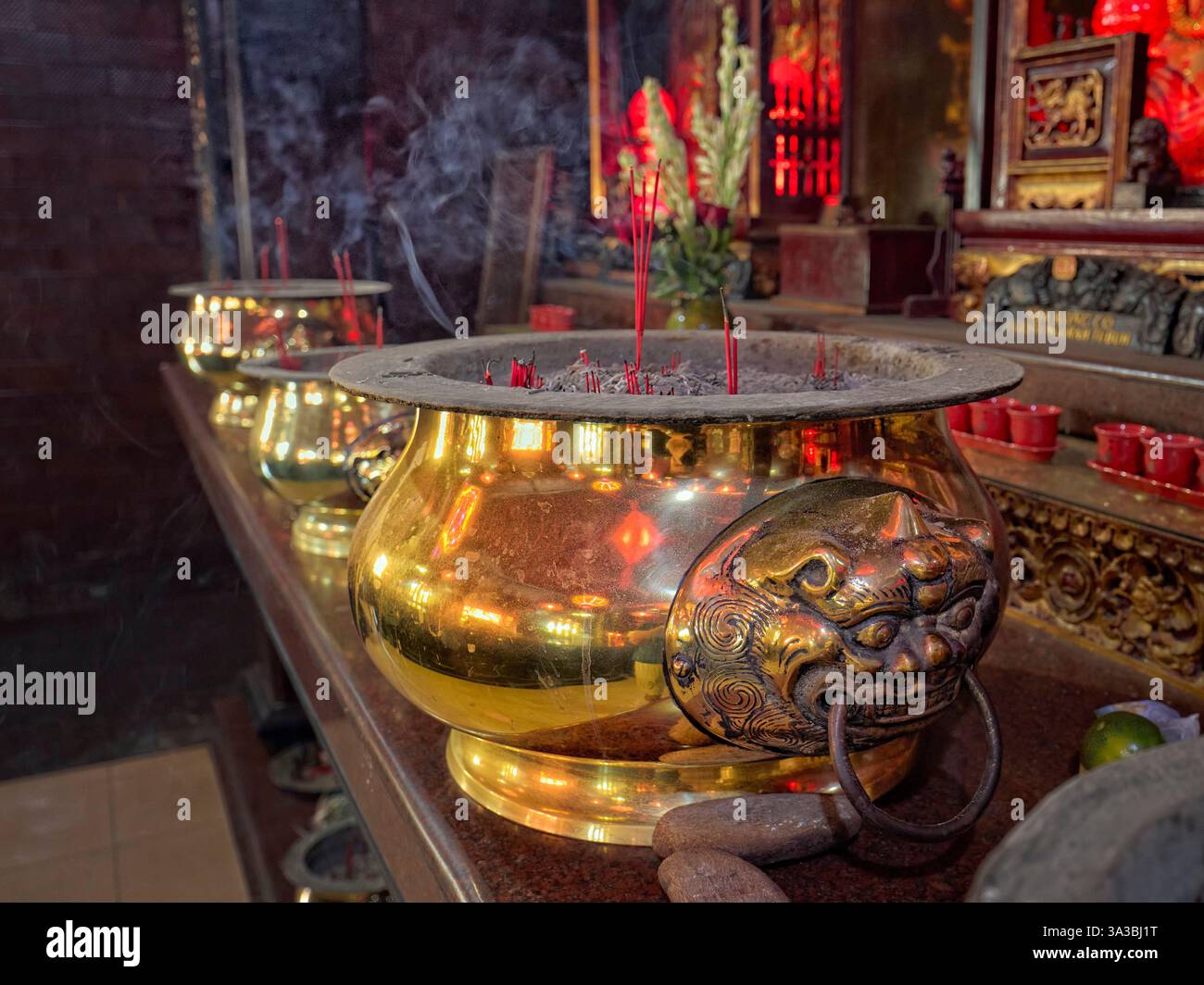 Golden urns with smoking incense sticks on the table at the altar in ...
