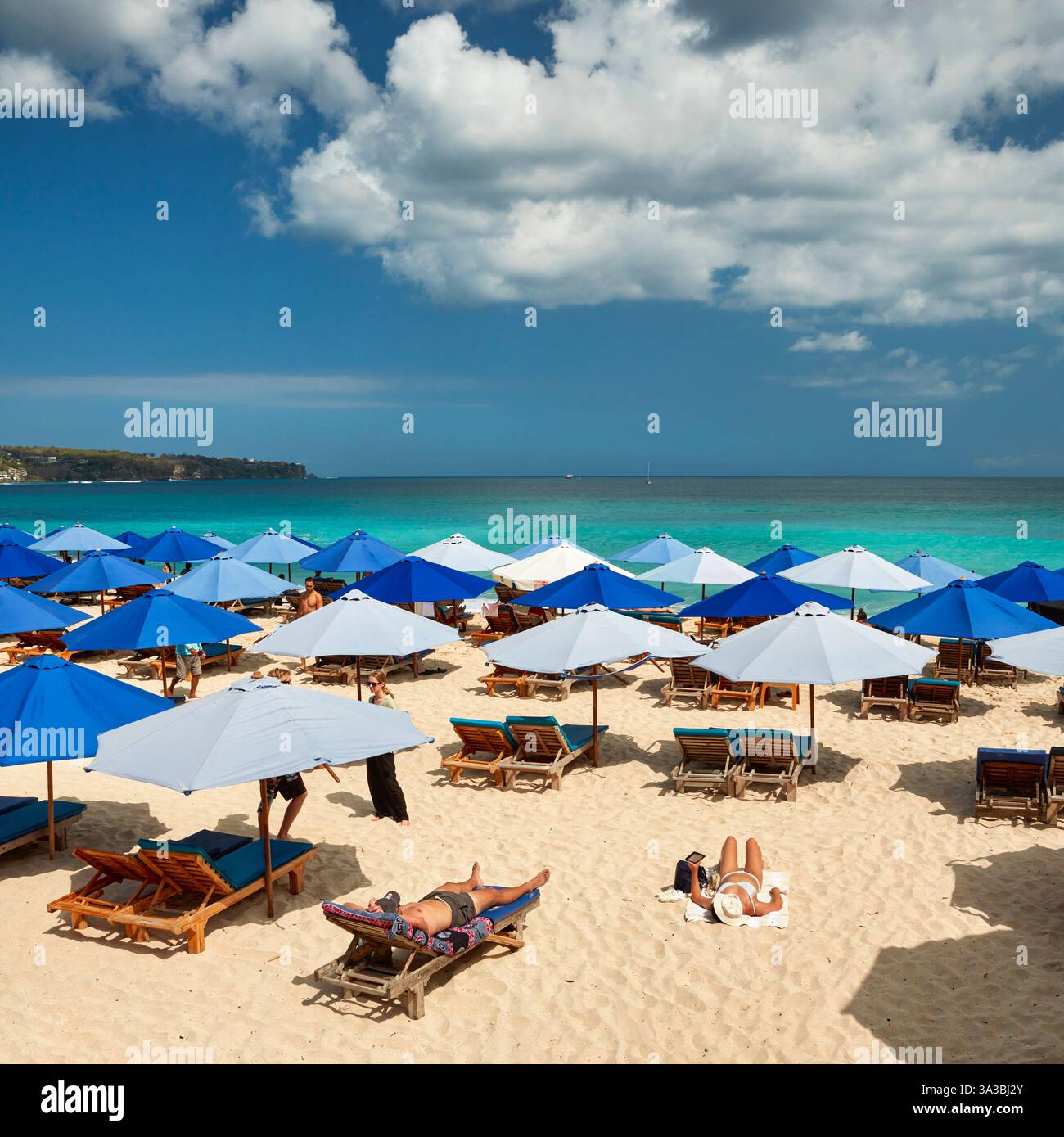 People sunbathe on the sandy Dreamland Beach. Bukit peninsula, Bali ...