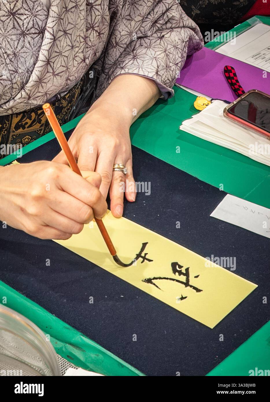 An artist s hand guides a calligraphy brush, creating traditional ...