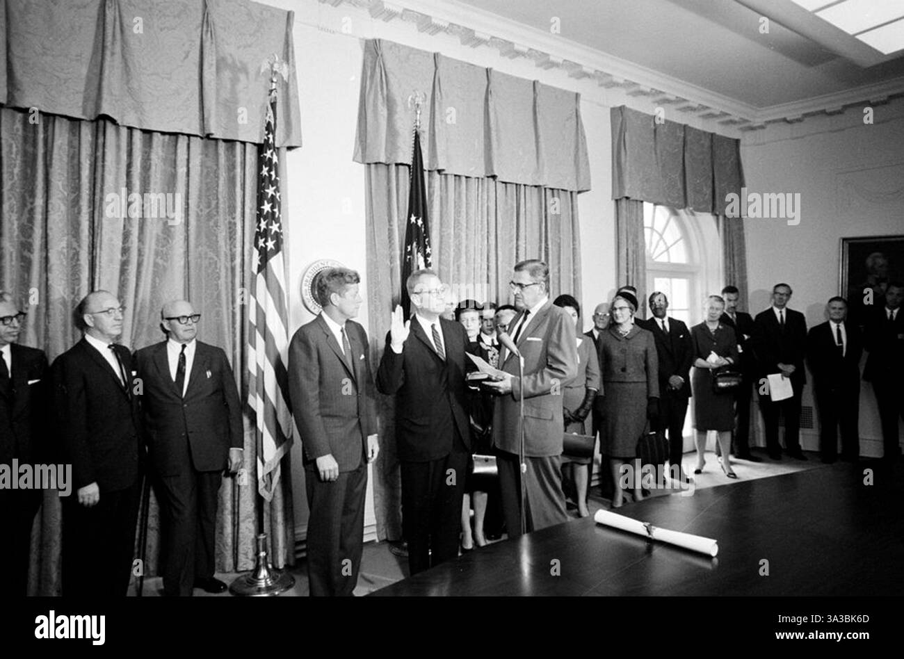 President John F. Kennedy observes as W. Willard Wirtz (center) is ...
