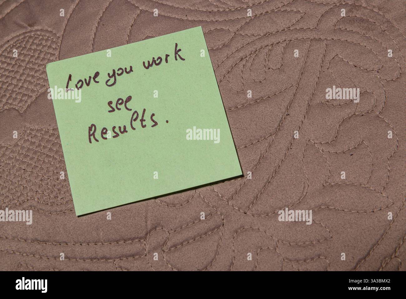 A green sticky note with handwritten words of encouragement is placed ...