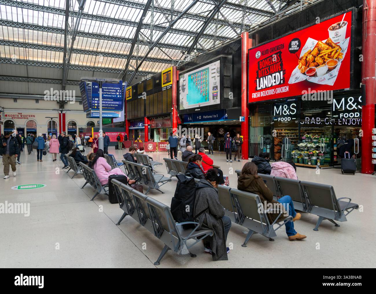 People sitting in seats in concourse area of Lime Street railway ...