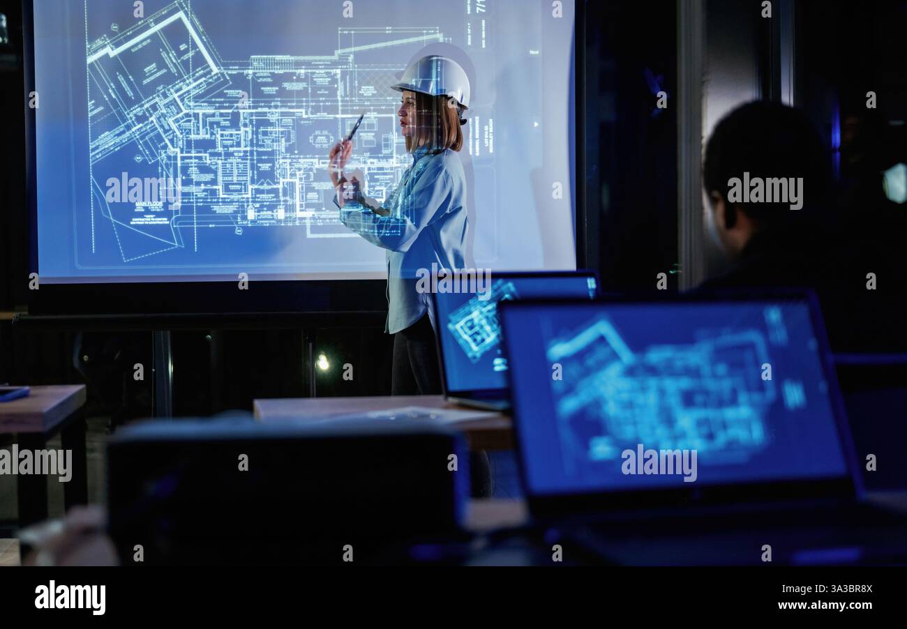 In white hard hat. Female architect is showing construction site plan ...