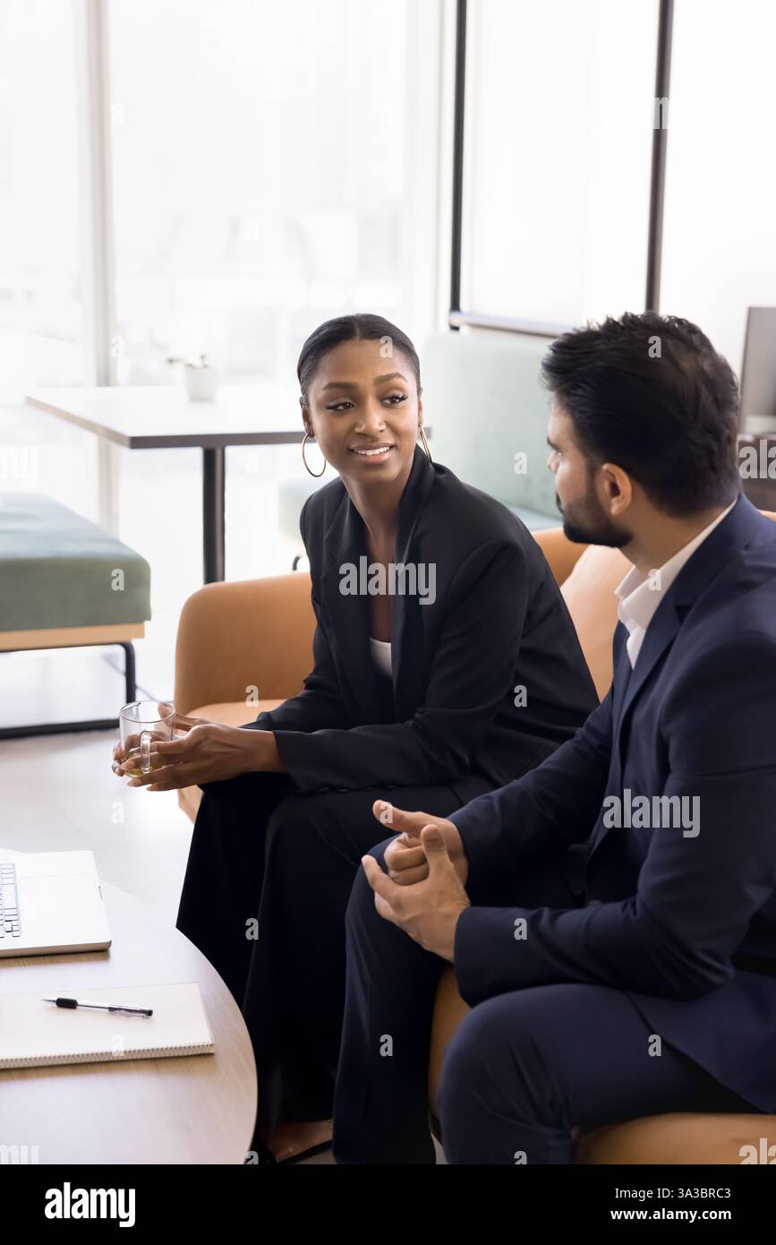 Two multiethnic male, female professionals engaged in conversation ...