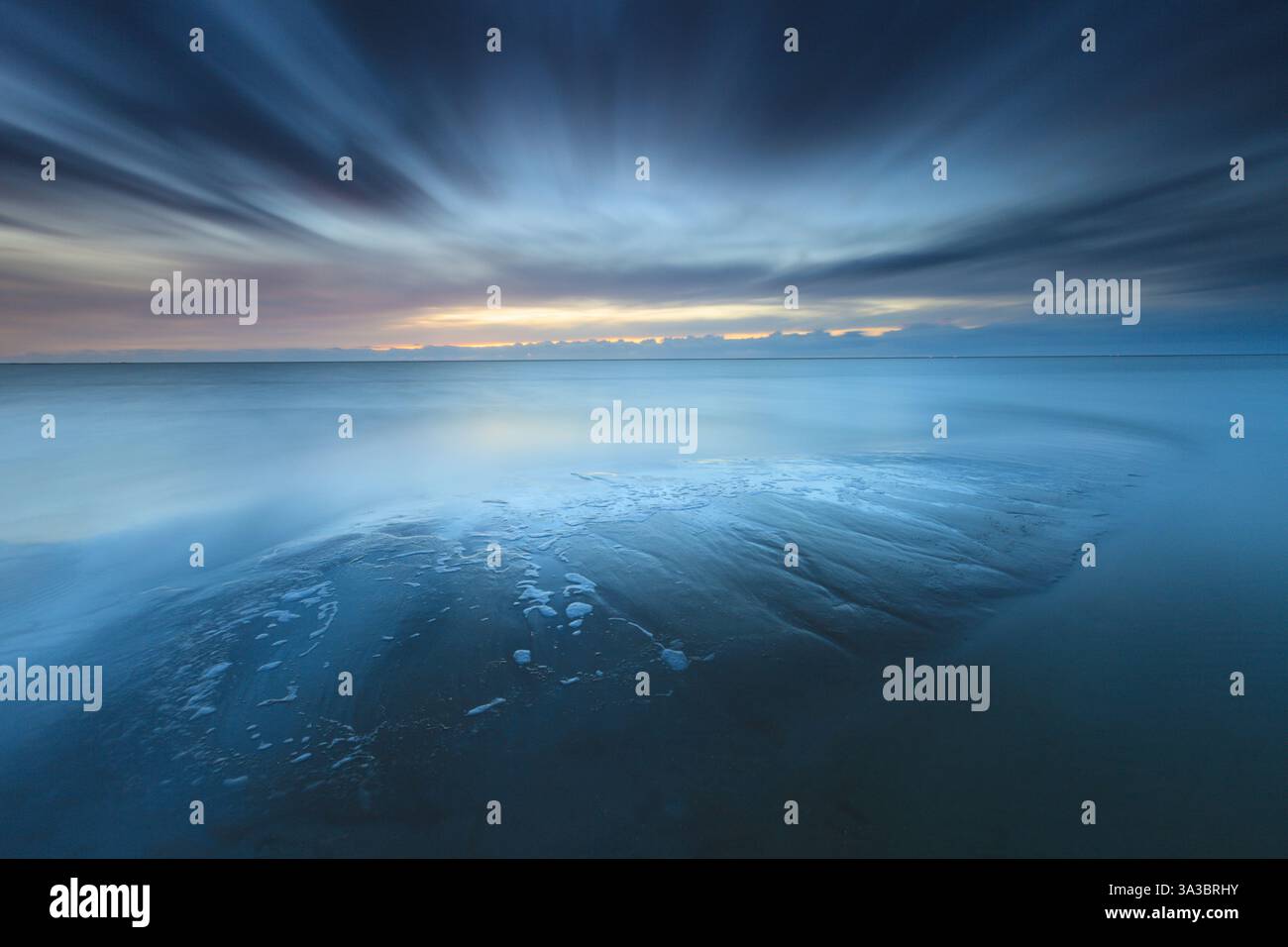 Clouds flowing by as the sun disappears under the horizon at Lake ...