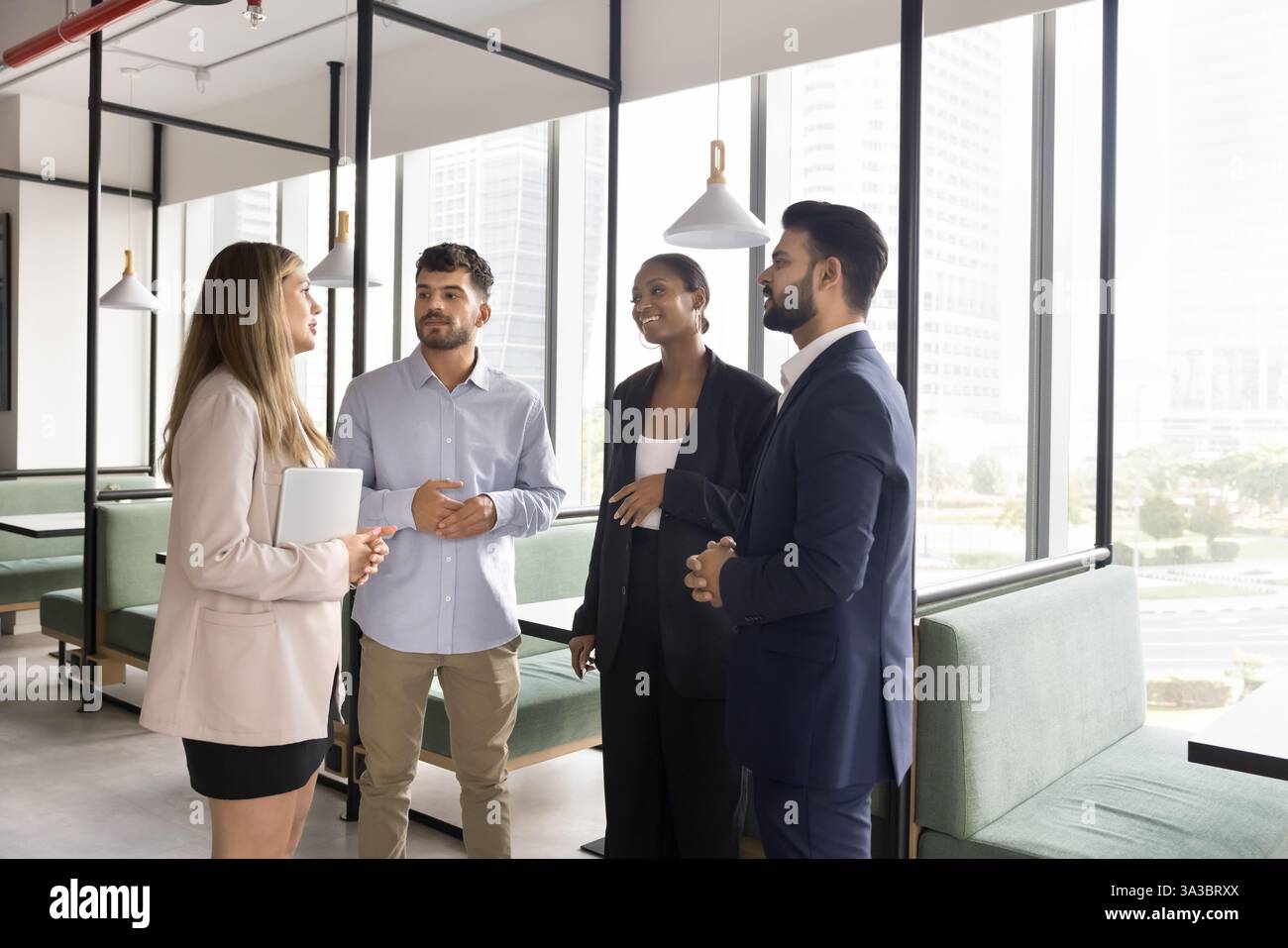 Four diverse teammates co-workers talking met in modern co-working ...