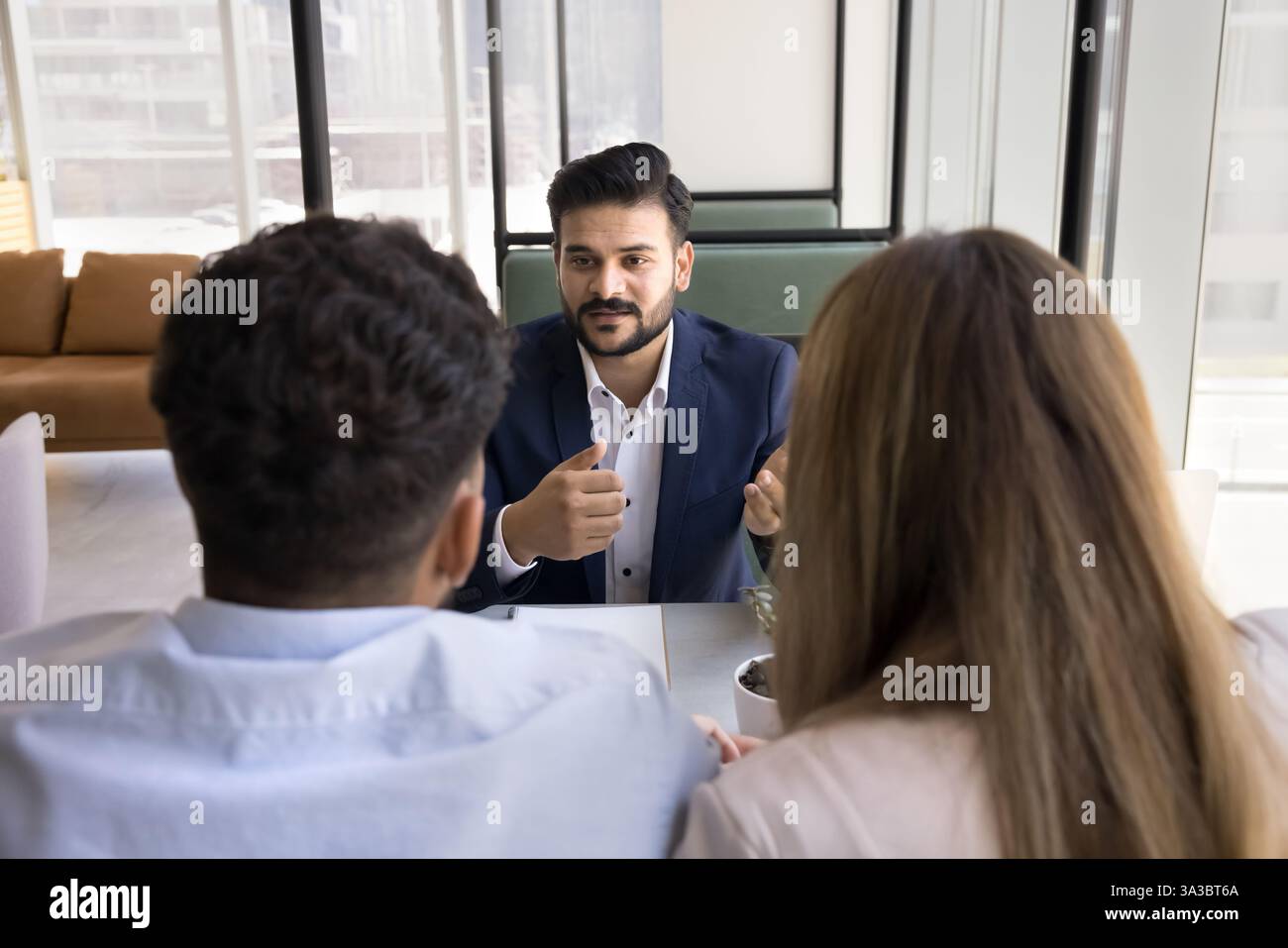 Agent consulting young couple during meeting in office Stock Photo - Alamy