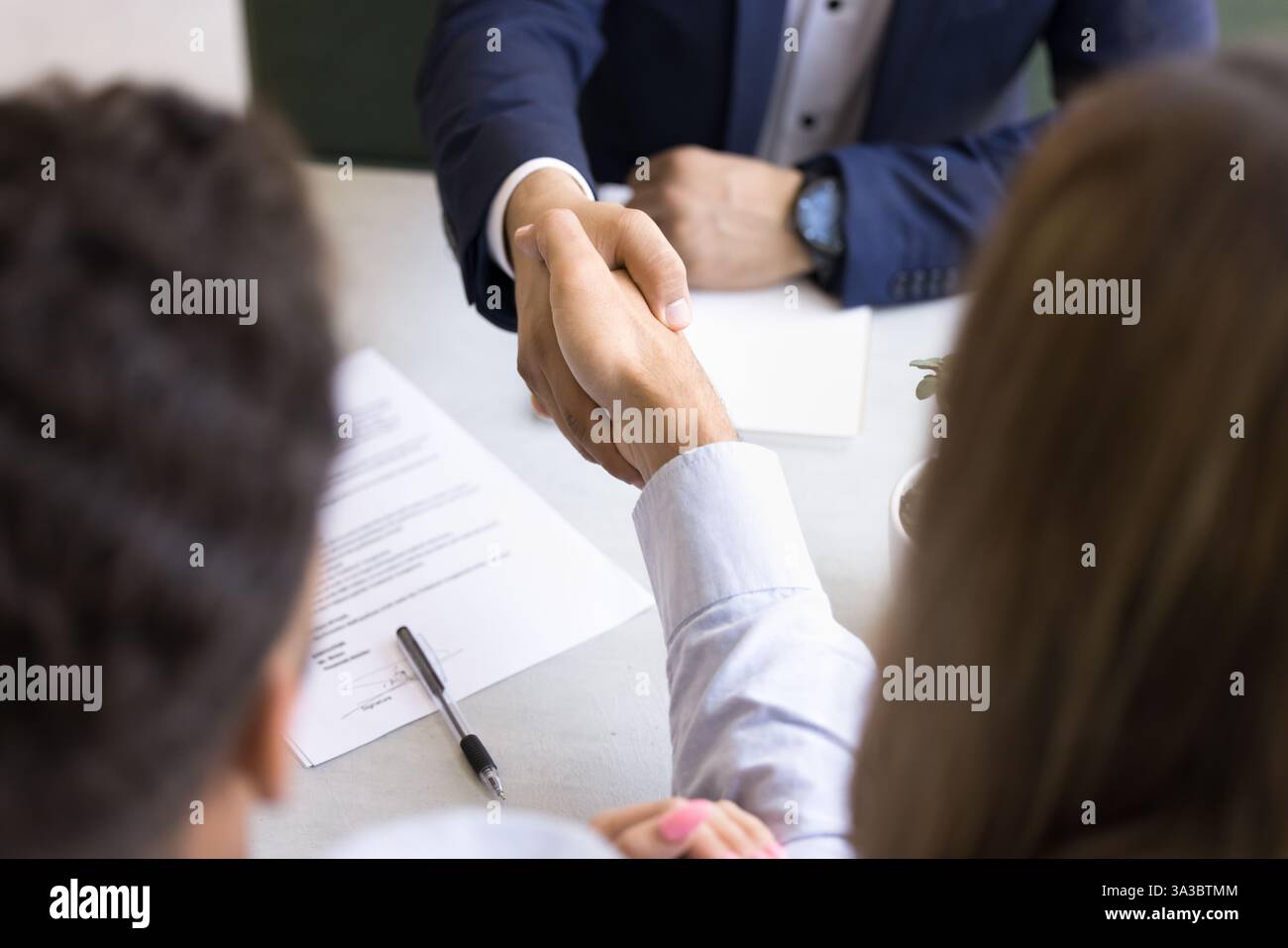 Above close up view of people shaking hands across table Stock Photo ...