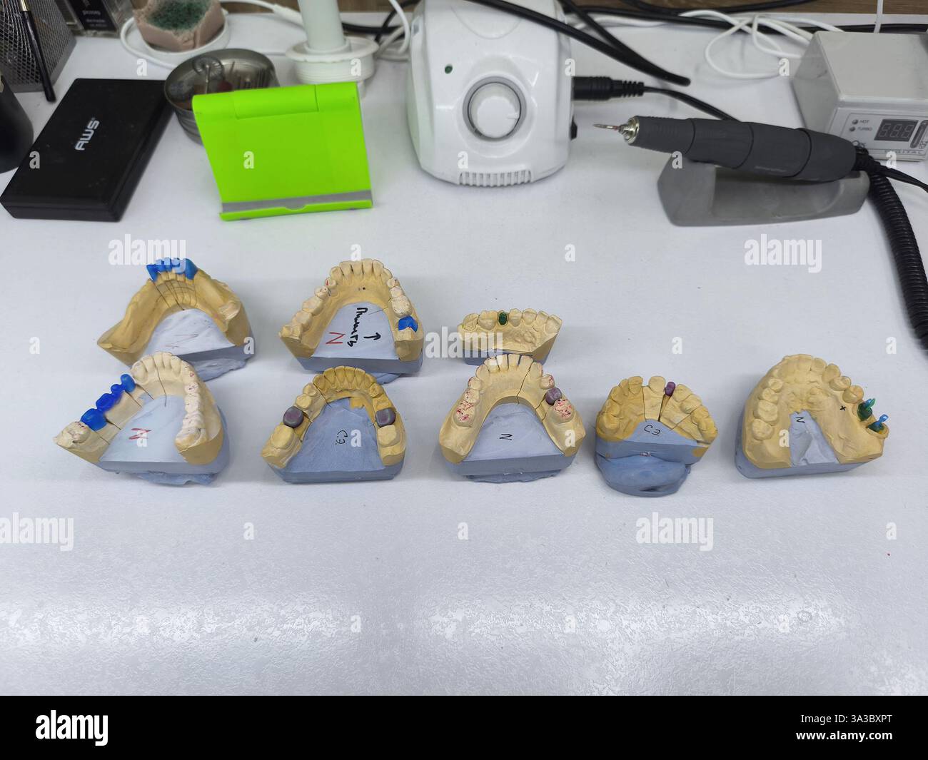 Dental prosthetic models on lab workbench with equipment Stock Photo ...