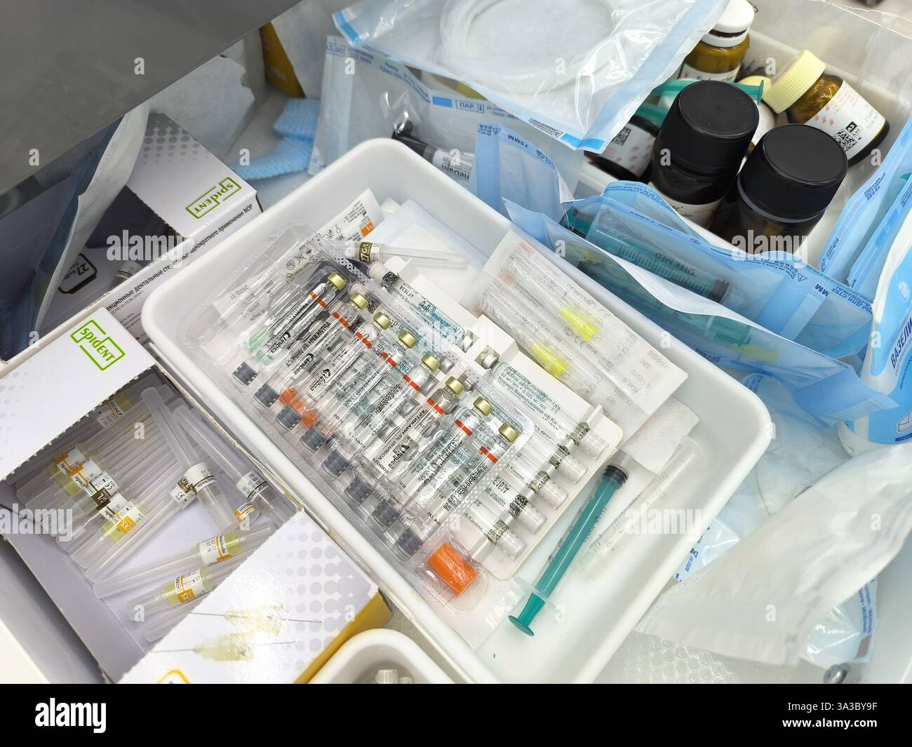 Organized medical supplies with syringes and vials in sterile packaging ...