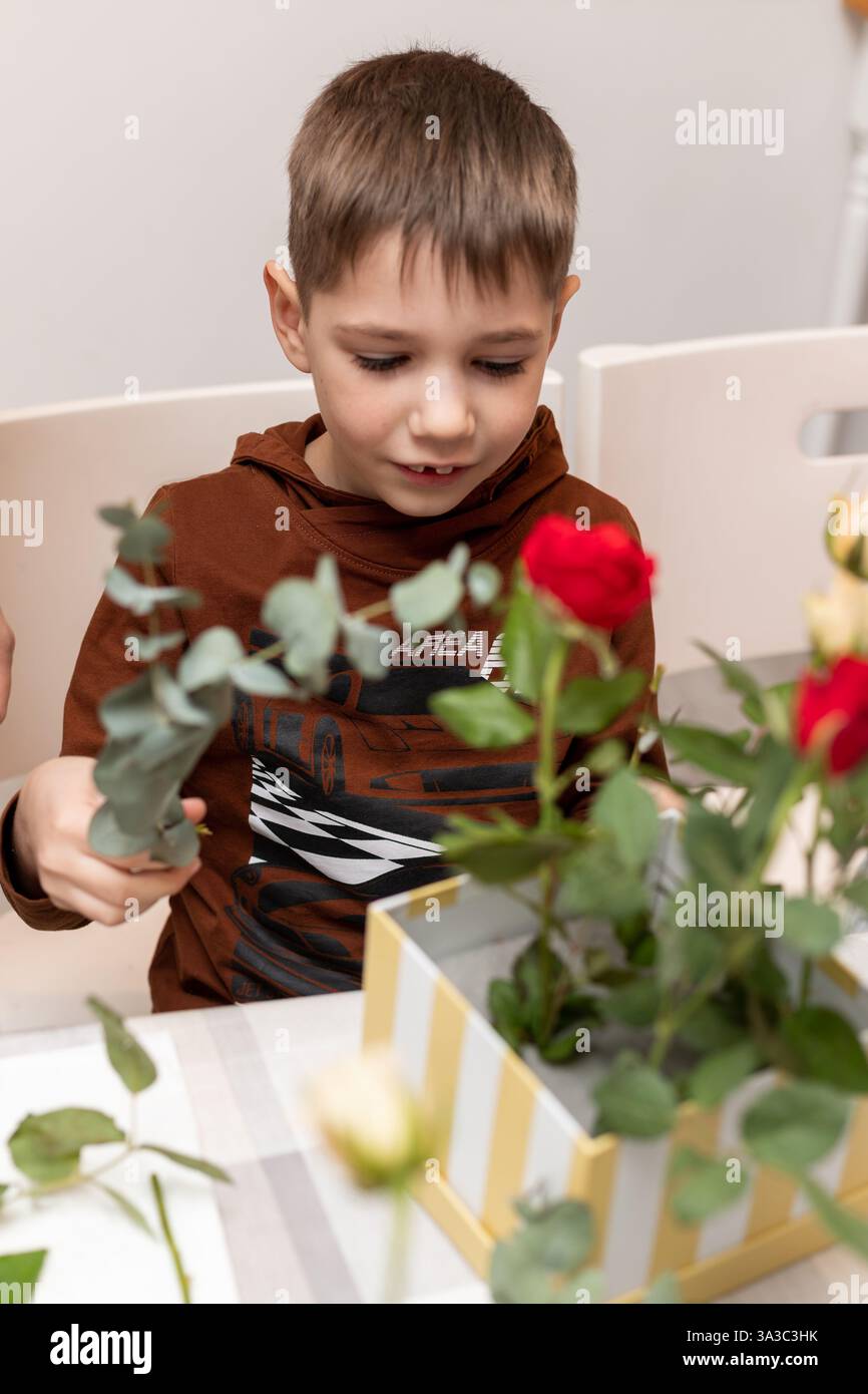 A child makes a handicraft with his own hands for Mother's Day. Boy ...