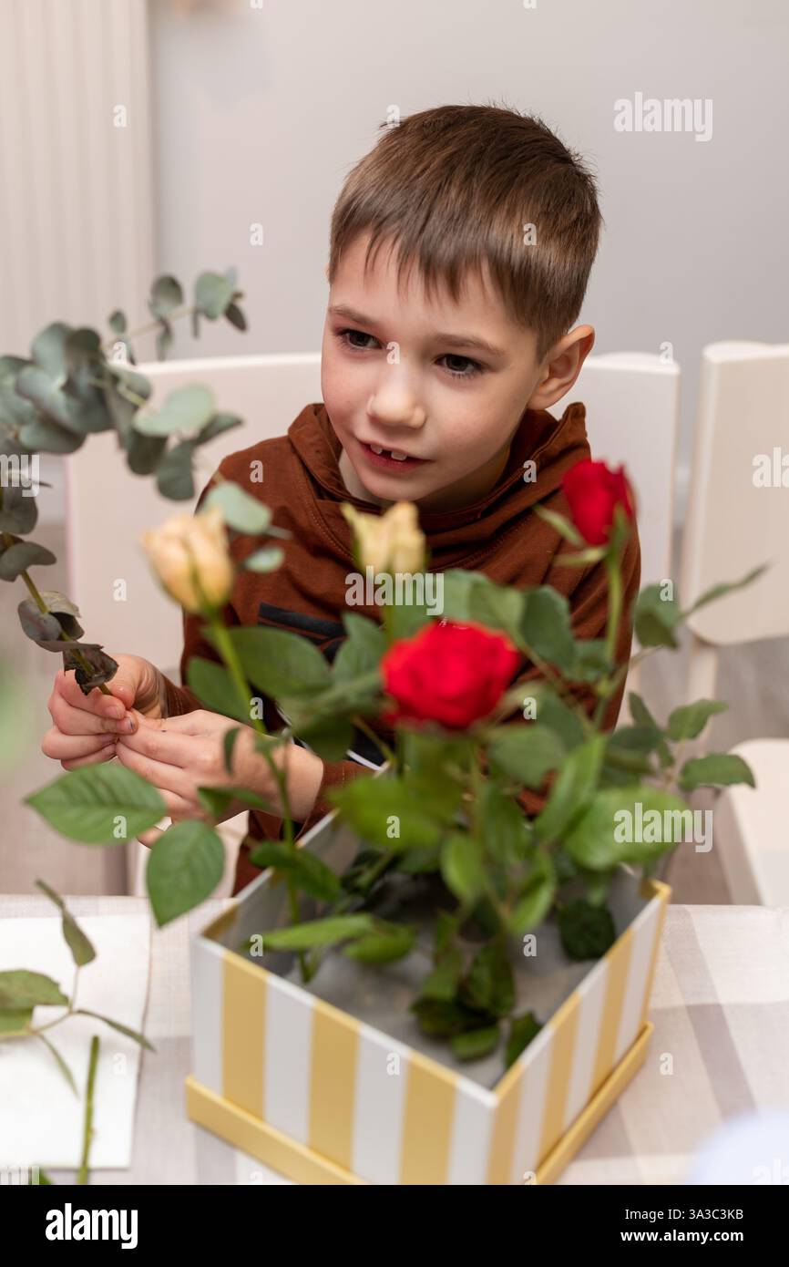 A child makes a handicraft with his own hands for Mother's Day. Boy ...