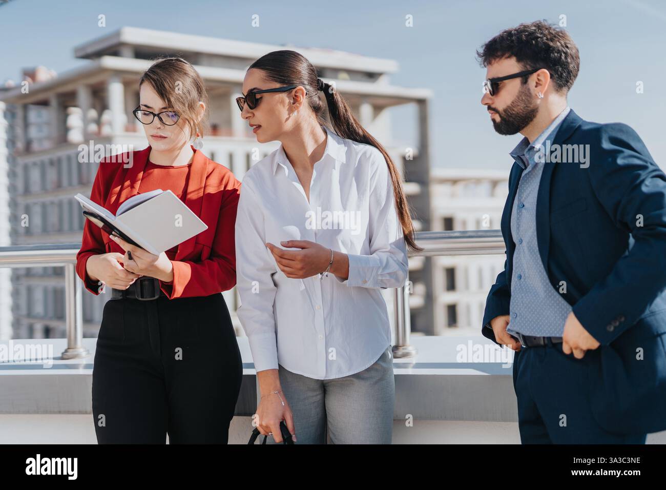 A diverse group of people stands on a rooftop terrace, engaged in a ...