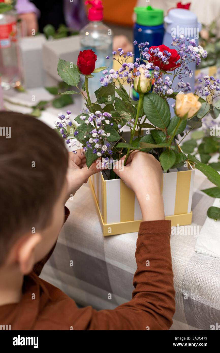 A child makes a handicraft with his own hands for Mother's Day. Boy ...