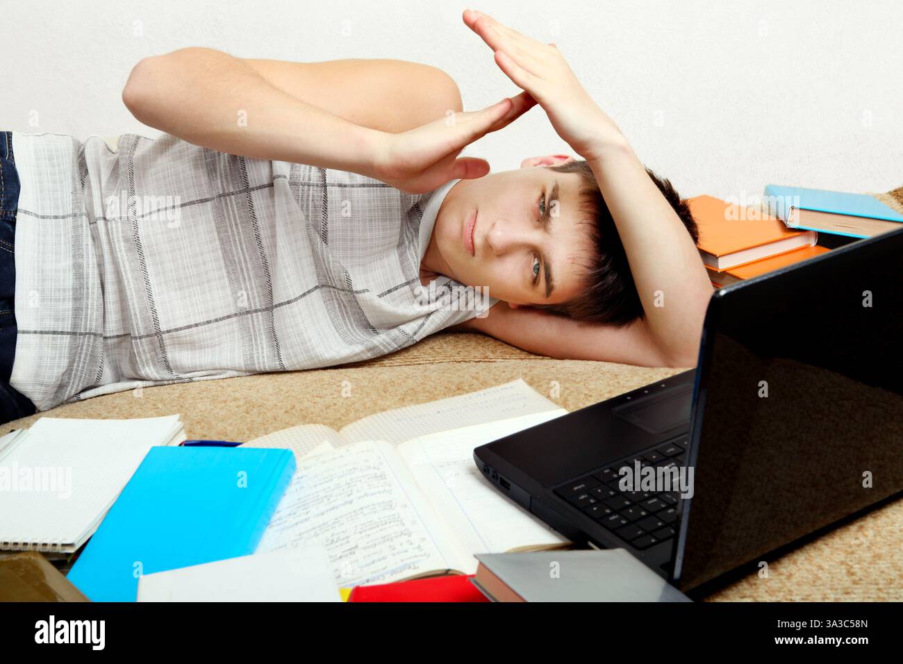 Tired Student on Sofa showing Time Out Gesture Stock Photo - Alamy